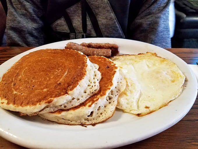 The classic American breakfast in its natural habitat – pancakes with the ideal golden hue, eggs with perfect runny yolks, and a side of nostalgia.