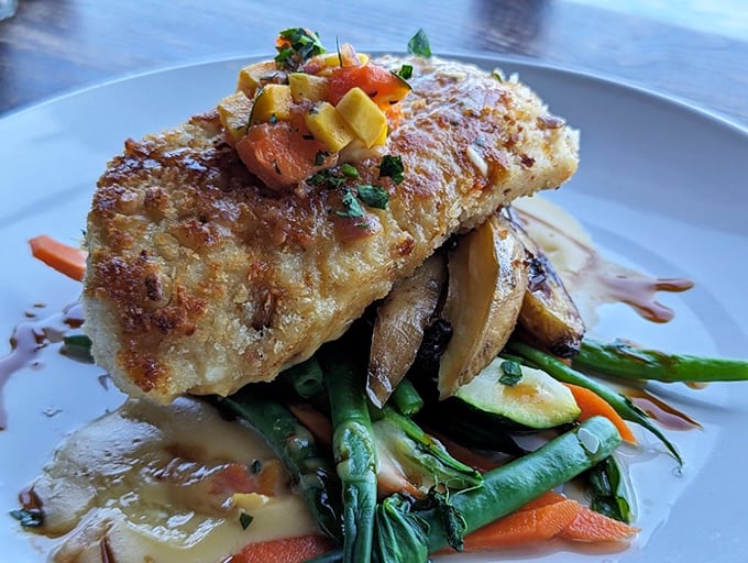 The Macadamia Crusted Halibut sits atop vegetables like a seafood crown jewel, practically begging for its own Instagram account.