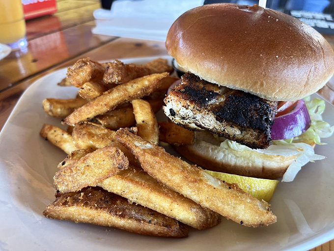 This blackened mahi sandwich isn't just lunch – it's a monument to what happens when fish meets fire meets skill. Those fries aren't slouching either.