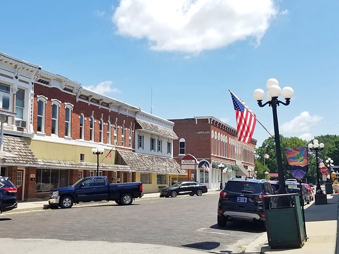 Main Street Arcola, where American flags wave proudly and brick buildings stand shoulder to shoulder, creating that quintessential small-town atmosphere we all secretly crave.