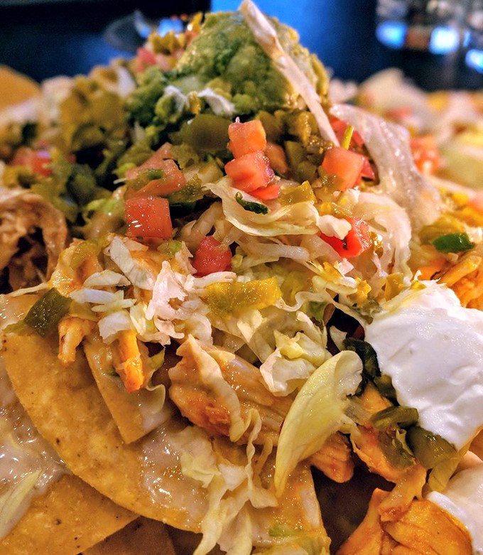 Architecture meets appetite with these nachos—each layer a carefully constructed flavor neighborhood where no chip is left behind.
