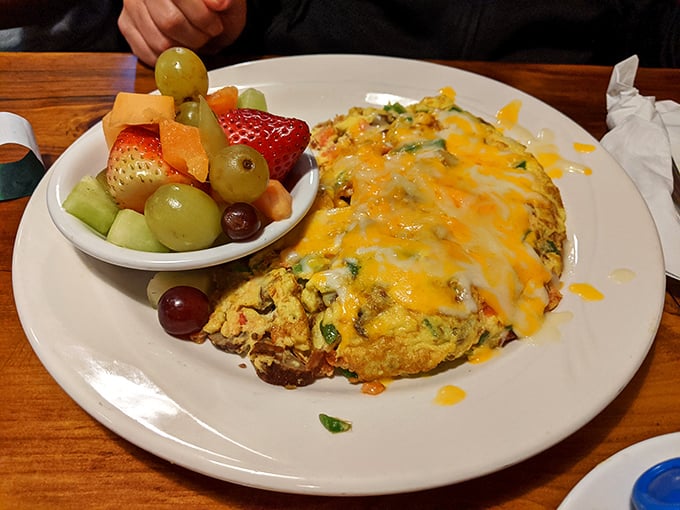 An omelet that doesn't just whisper "good morning" – it belts out "HELLO SUNSHINE!" with cheese, veggies, and a side of fresh fruit.