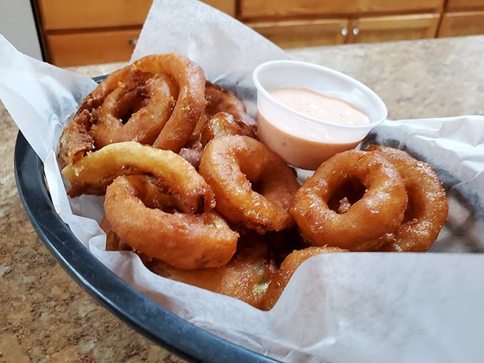 These onion rings aren't just fried—they're transformed. Crispy, golden halos of happiness served with a dipping sauce that makes you wonder why vegetables ever bothered being healthy.