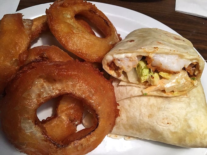 A wrap that means business alongside onion rings that achieve the perfect crunch-to-sweetness ratio—proof that simple food done right is culinary poetry.