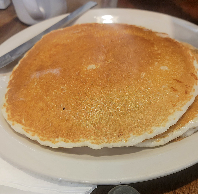 The pancake that launched a thousand road trips—golden-brown, fluffy, and wider than your smile will be after the first bite.