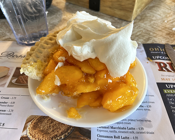 Summer captured in a pie shell—this peach masterpiece topped with whipped cream is what fruit dreams about becoming when it grows up.