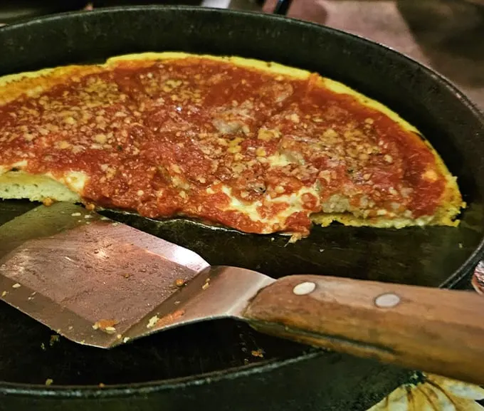 The star of the show—pan pizza with that perfect cornmeal-dusted crust and sauce that required generations to perfect. Worth every minute of the wait.