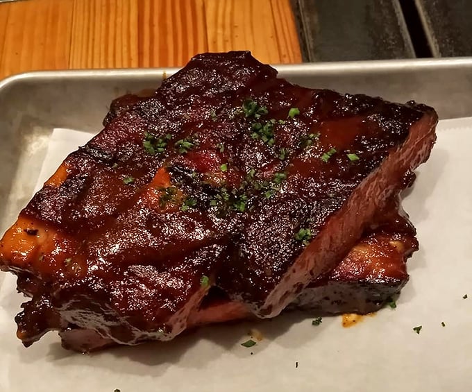 These ribs have that perfect lacquered glaze that makes you want to cancel your afternoon appointments. The meat doesn't fall off the bone—it respectfully parts ways when asked.