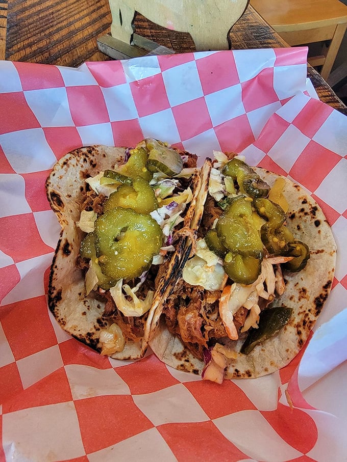 Pickles and slaw provide the perfect acidic counterpoint to smoky pulled pork tacos – proof that balance exists in the barbecue universe.