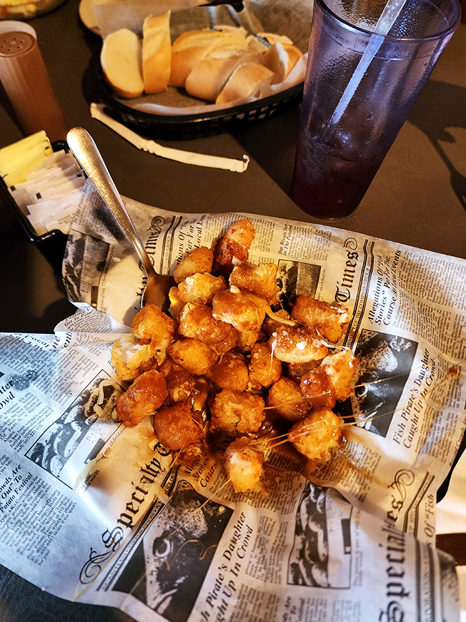 Crispy cheese curds nestled on newspaper—proof that sometimes the best culinary experiences come without fancy china or white tablecloths.