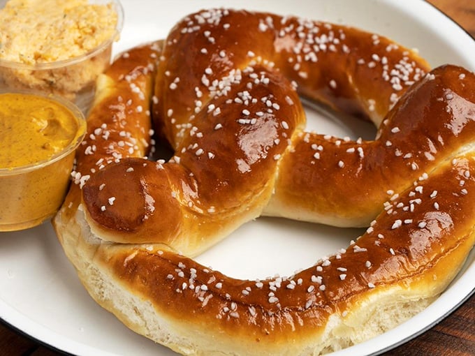 This isn't just any pretzel – it's architectural genius with carbs. The accompanying dips aren't sidekicks; they're equal stars in this show.