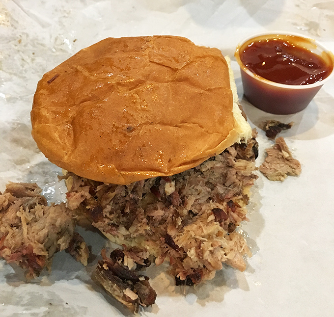 The pulled pork sandwich – where bread becomes merely a delivery system for smoky, saucy perfection.