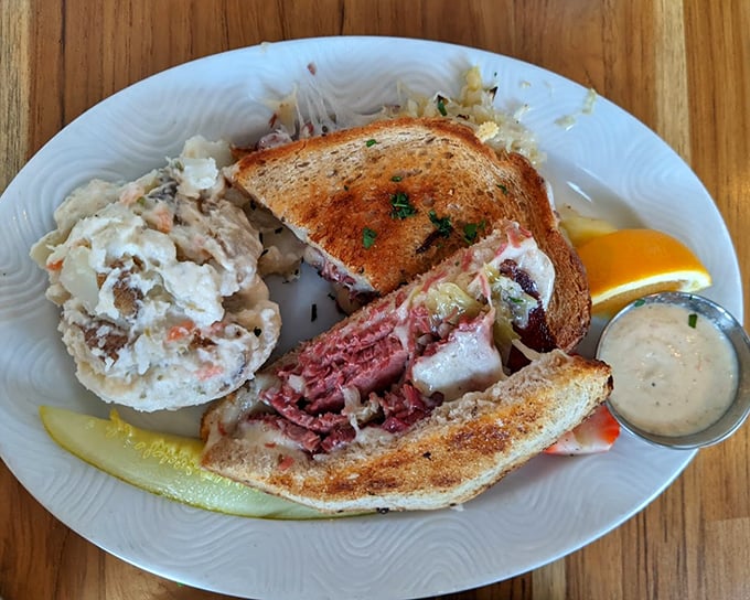 A Reuben sandwich so perfectly constructed it could teach architecture classes, with a side of potato salad that refuses to be overshadowed.