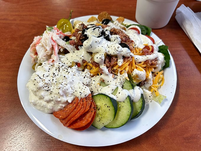 Salad architecture at its finest—where ranch dressing cascades like a creamy waterfall over a foundation of crisp vegetables and savory toppings.