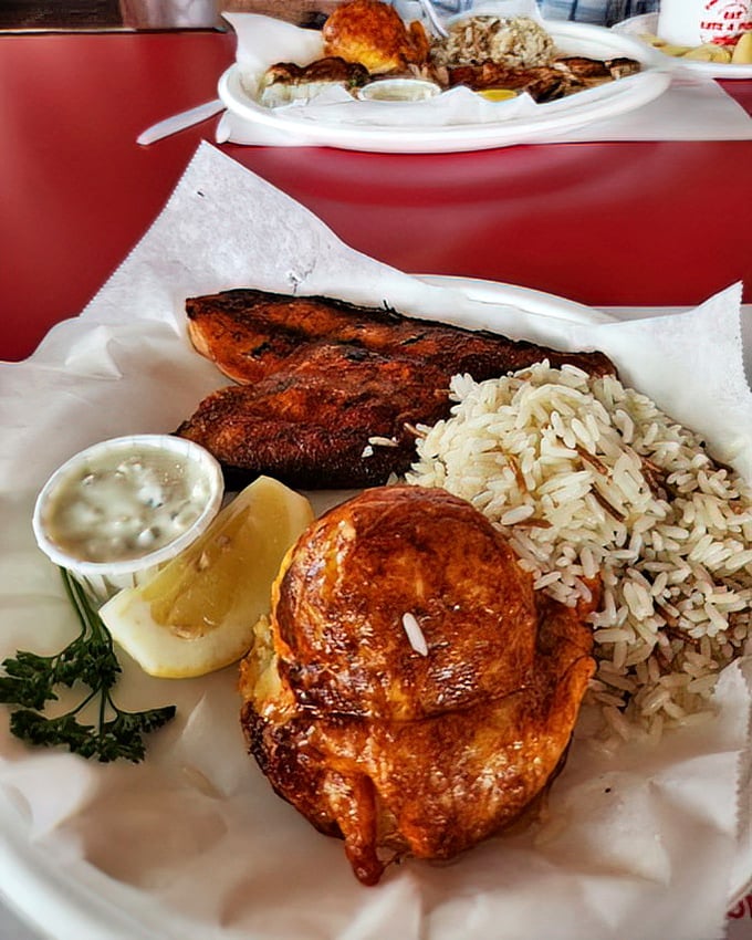 The seafood trifecta: perfectly grilled fish, a golden crab cake, and rice pilaf—proof that sometimes the simplest combinations create the most memorable meals.