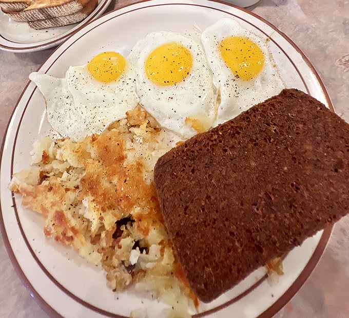 Three sunny-side-up eggs standing at attention next to home fries and scrapple. Delaware's breakfast trifecta that makes avocado toast seem like a passing fad.