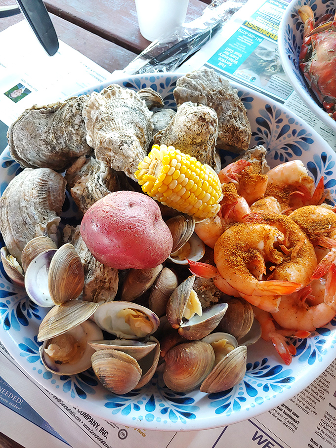 The seafood sampler that makes decisions unnecessary. Oysters, clams, shrimp, and corn—a maritime block party on a plate.