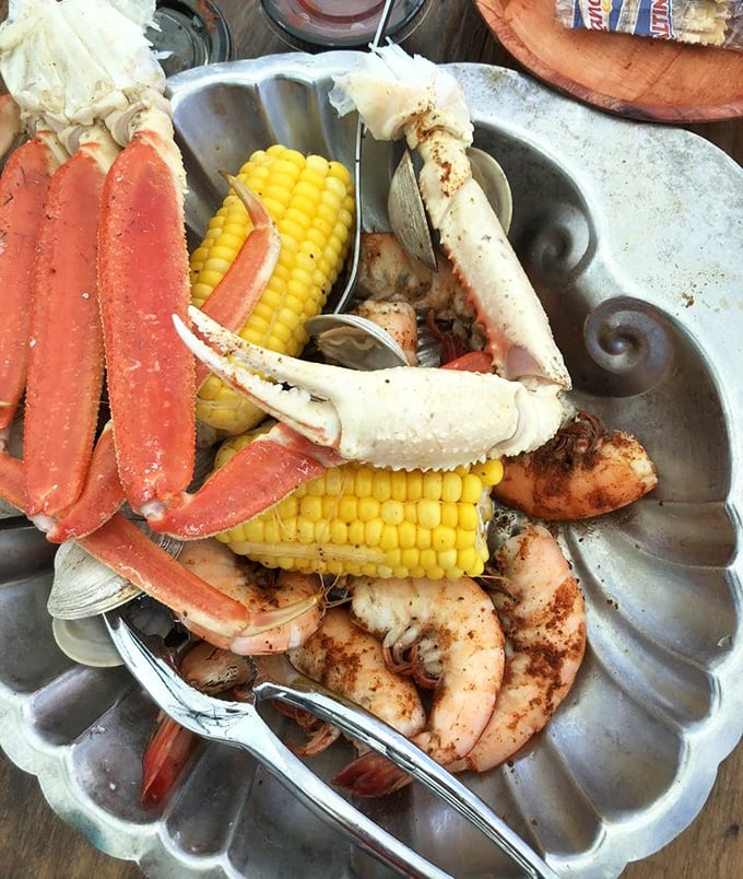 The ultimate seafood celebration – crab legs, shrimp, and corn on the cob. This metal platter holds more treasure than most pirate ships.