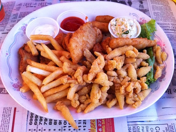 The seafood platter that launched a thousand return trips – crispy, golden treasures from the deep atop a bed of fries.