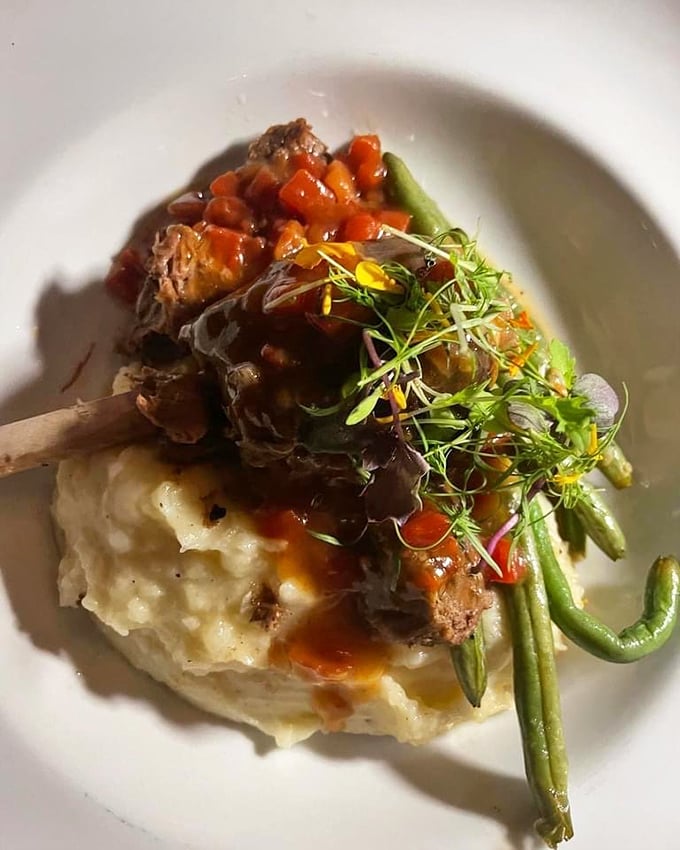 Short ribs so tender they practically surrender to your fork, resting on mashed potatoes that could make a cloud jealous.