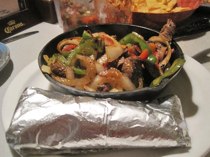 Sizzling fajitas that announce their arrival before you see them, paired with a foil-wrapped bundle of warm tortillas waiting to be filled.