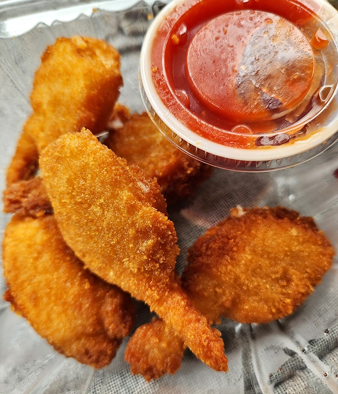 Golden-fried seafood bites paired with tangy cocktail sauce—proof that sometimes the simplest pleasures are the most satisfying.