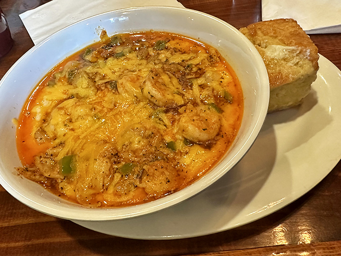 This bowl of shrimp and grits isn't just a meal—it's a warm, cheesy hug with seafood on top and a side of cornbread for good measure.