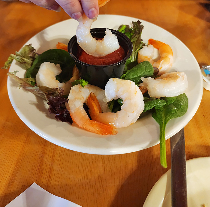 These shrimp are dressed to impress, circling a pool of zesty cocktail sauce. The lettuce? Just there for the fancy vibes.”