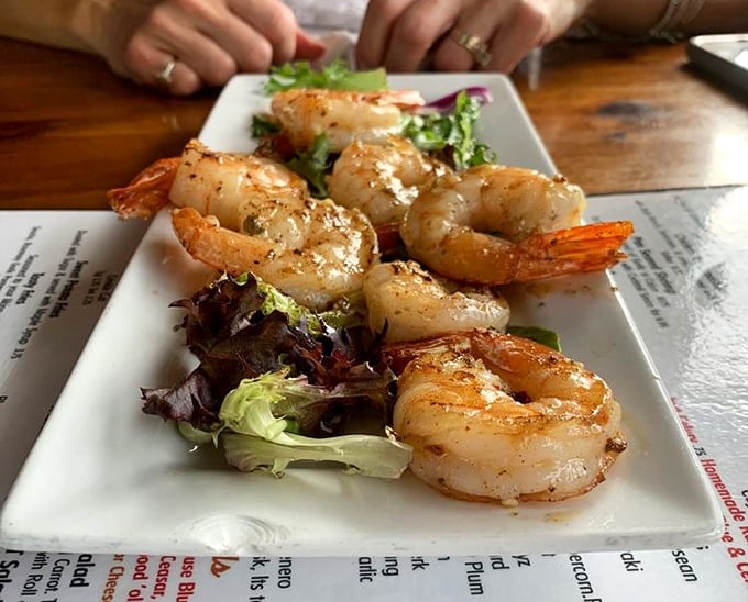 Perfectly seared shrimp perched atop fresh greens—proof that tavern food can be deliciously sophisticated when it wants to be, without getting all fancy-pants about it.