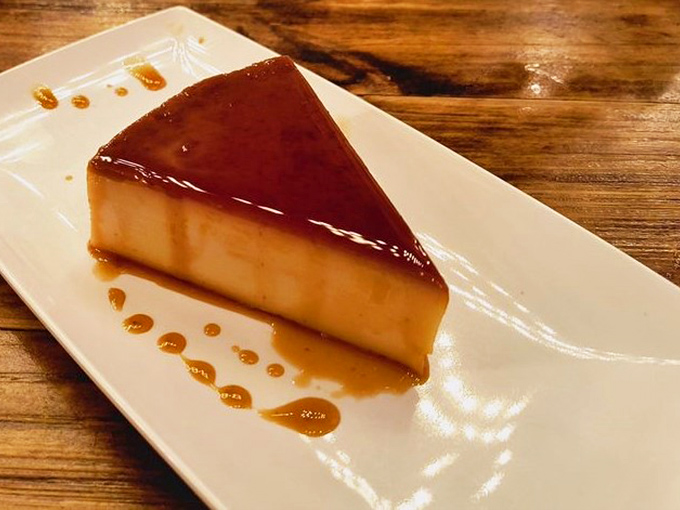 This isn't just flan—it's smoked flan, because regular desserts are for restaurants that lack imagination. The caramel pools like liquid amber.