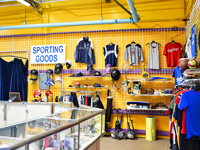 The sporting goods wall is a retirement home for athletic dreams—baseball gloves, team jerseys, and equipment just waiting for their second season.