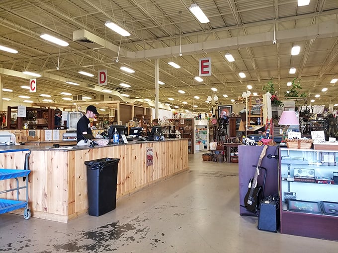 The central checkout area, marked by overhead letters, serves as command central for this sprawling vintage universe. Organization amid creative chaos.