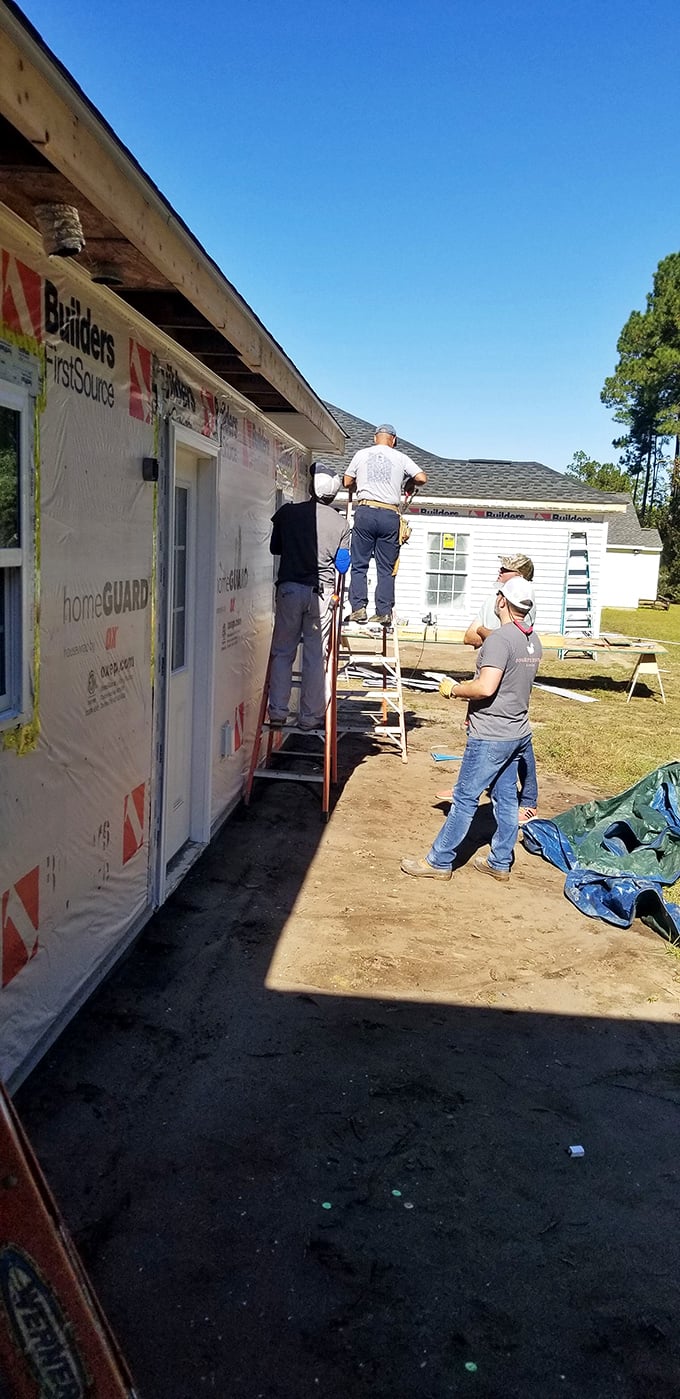Where houses become homes—volunteers working on a Habitat build. Your ReStore purchases directly fund these life-changing construction projects.
