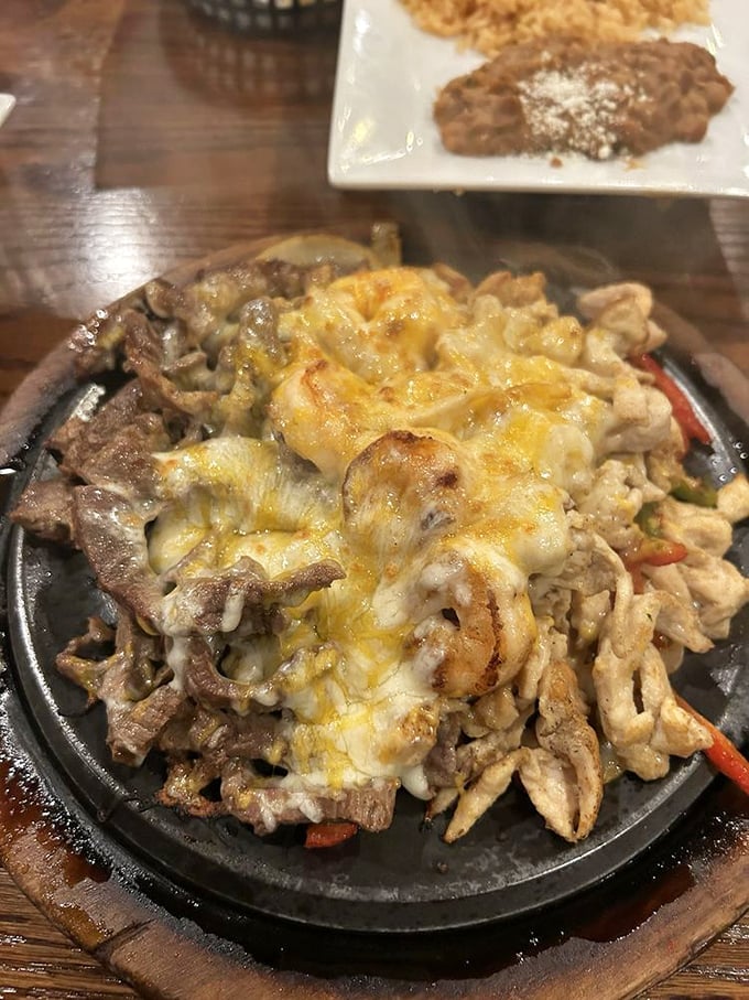 The sizzling fajita platter—where dinner and dramatic entrance become one glorious, cheese-covered spectacle that turns every head in the room.