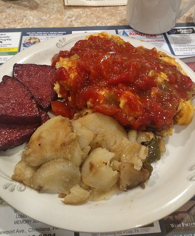 A plate that tells a story of Pennsylvania comfort—rich stewed tomatoes, potatoes, and what appears to be Lebanon bologna, a trio of regional favorites.