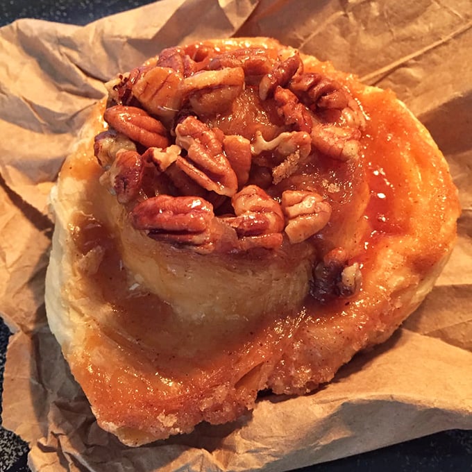 Behold the sticky bun in its natural habitat—glistening with caramel and crowned with pecans like the royalty of breakfast pastries it truly is.