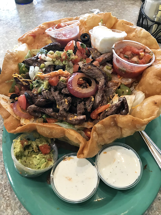 This isn't just a taco salad—it's an edible fortress of flavor, complete with its own moat of sauces and a garrison of fresh toppings.