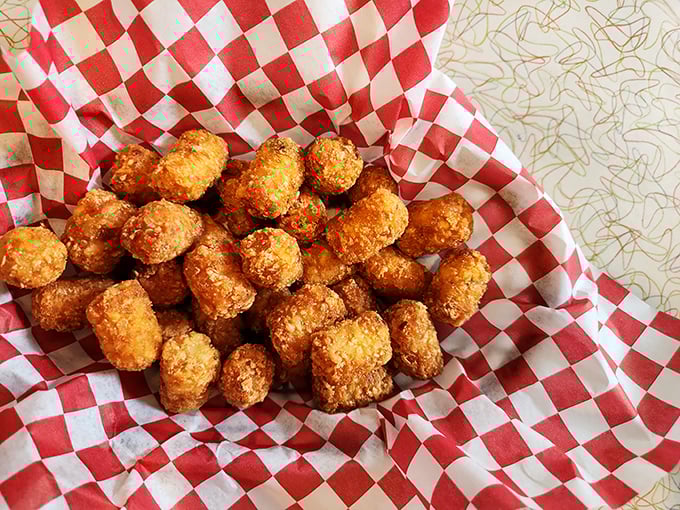 Golden-brown tater tots nestled in their checkered cradle—little nuggets of potato perfection that somehow taste even better than your childhood memories.