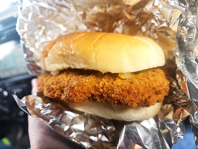 A breaded pork tenderloin sandwich that's practically wearing a golden crown. Royalty of the roadside, served on a humble throne.