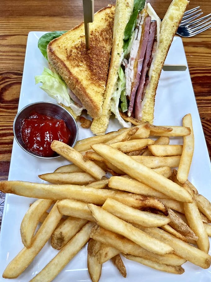 The Yacht Club sandwich stacks layers higher than Seattle rent prices, with fries that could make a Frenchman homesick.