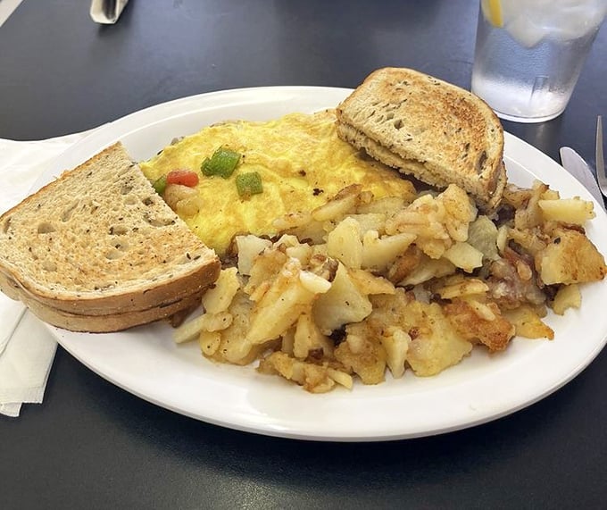 A proper diner breakfast: fluffy eggs nestled alongside golden home fries and hearty toast—simple perfection that fancy brunch spots try desperately to replicate.