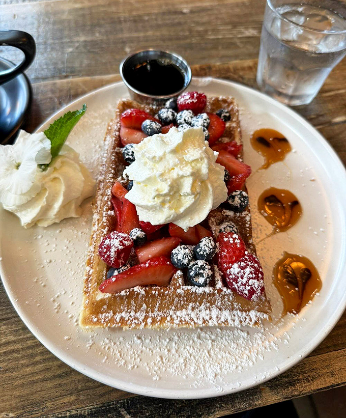 This berry-topped waffle with whipped cream is what breakfast looks like in your sweetest dreams – complete with maple syrup puddles.