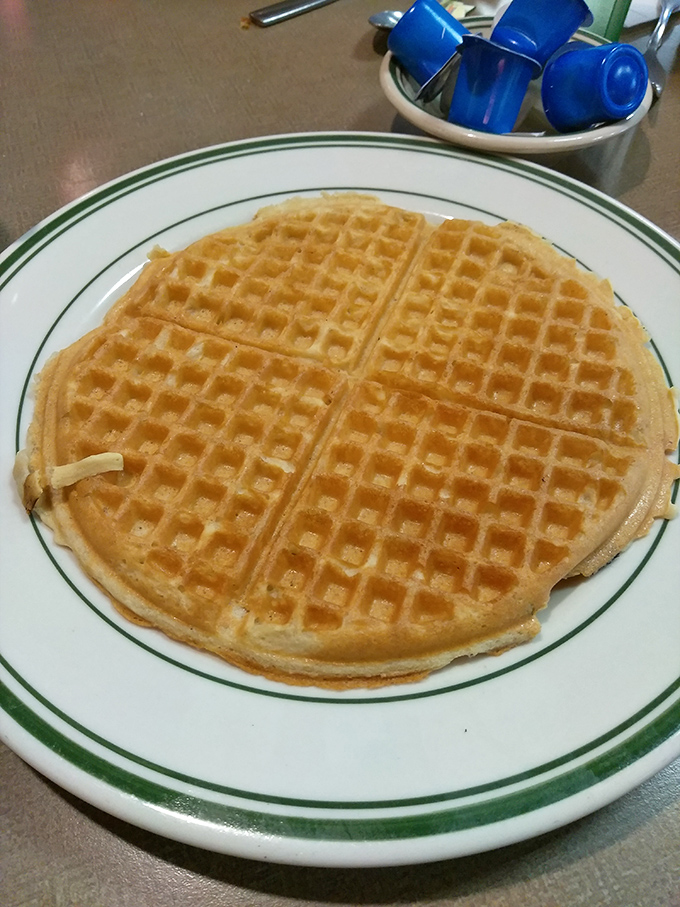 The waffle that launched a thousand breakfasts—golden, crisp-edged perfection waiting for its maple waterfall. Simple pleasures are often the most profound.