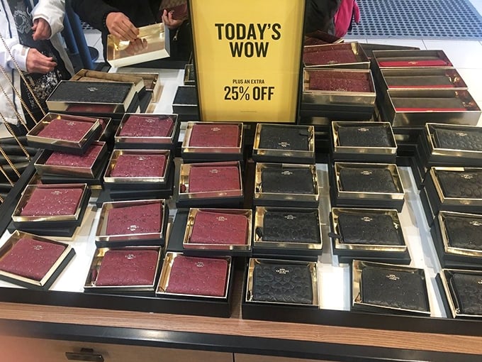 "Today's WOW" indeed – Coach wallets lined up like soldiers, their burgundy and black leather gleaming under strategic lighting.