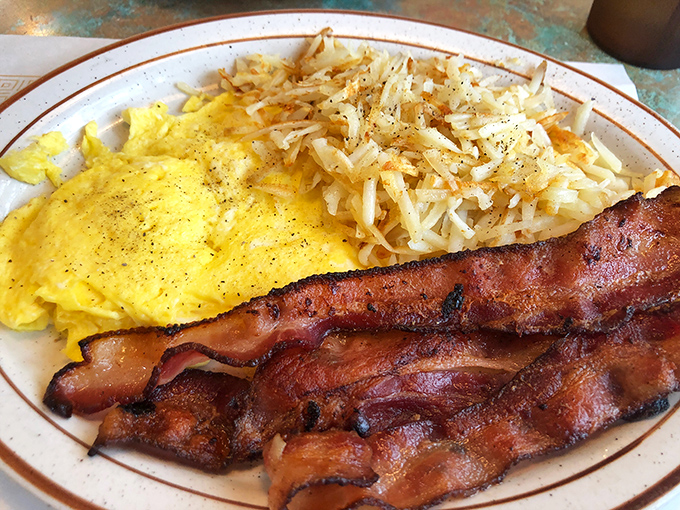 This isn't just breakfast—it's morning therapy. Golden omelet filled with western goodness beside bacon cooked to that perfect crisp-yet-chewy sweet spot.