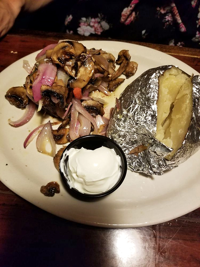 The legendary baked potato, wrapped in foil like the culinary gift it is. Those sautéed mushrooms and onions are its perfect dance partners.