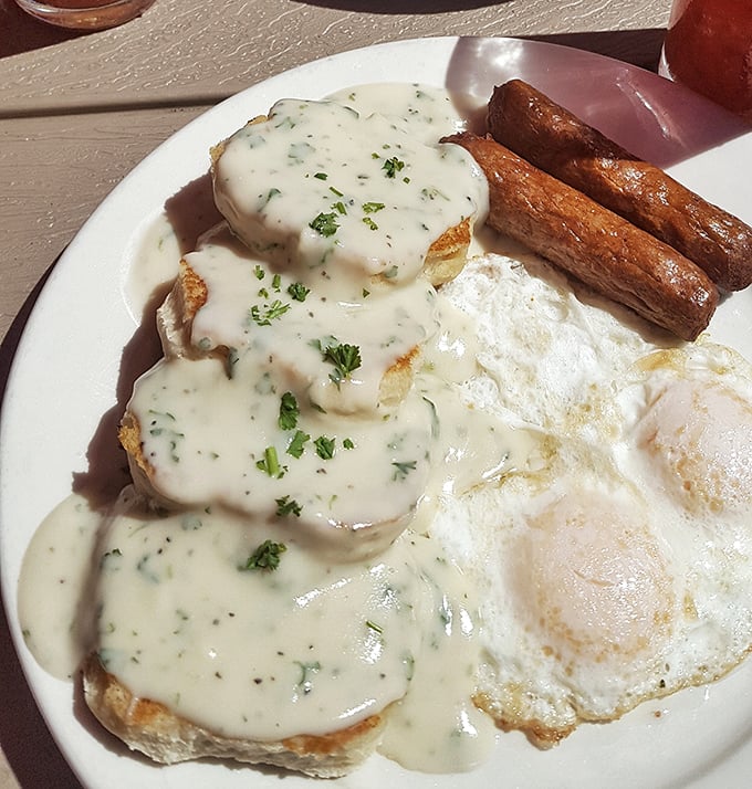The holy grail itself – fluffy biscuits drowning in creamy sausage gravy that could convert the most devoted pancake fan.
