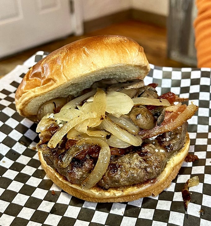 This burger isn't just topped with caramelized onions—it's crowned with them, creating a savory-sweet harmony that makes you forget you're eating in a checkered paper basket.