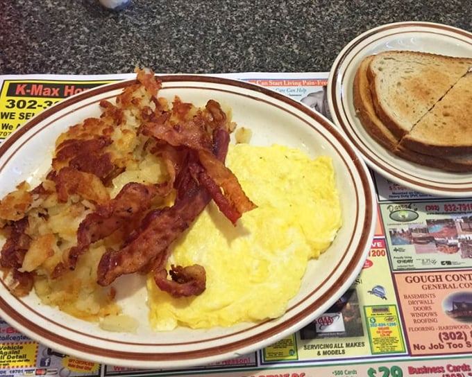 Breakfast perfection on a plate: crispy bacon, sunshine-yellow eggs, and home fries that could make a potato farmer weep with pride.