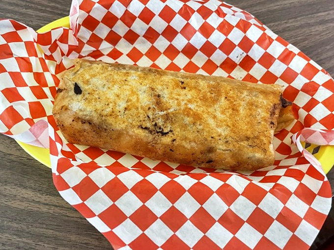 What appears to be a breakfast burrito wrapped in checkered paper—simple, substantial, and exactly what you'd want after a night of questionable decisions.